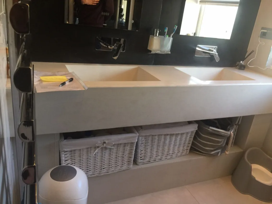 White concrete sink with shelf underneath & Black splash back on the wall